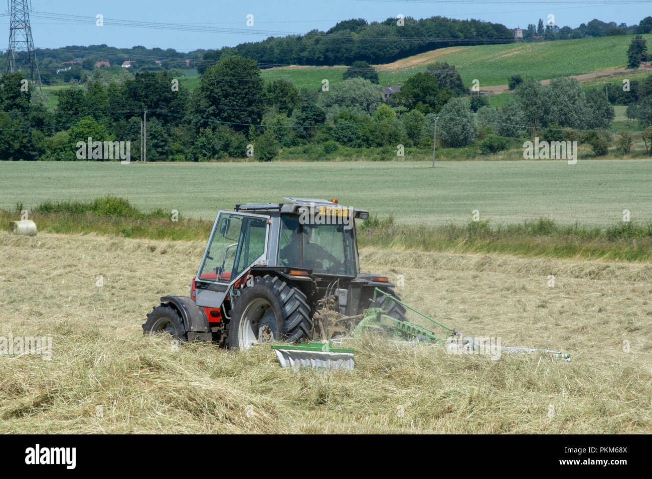 Tractor turning hay Stock Photo - Alamy