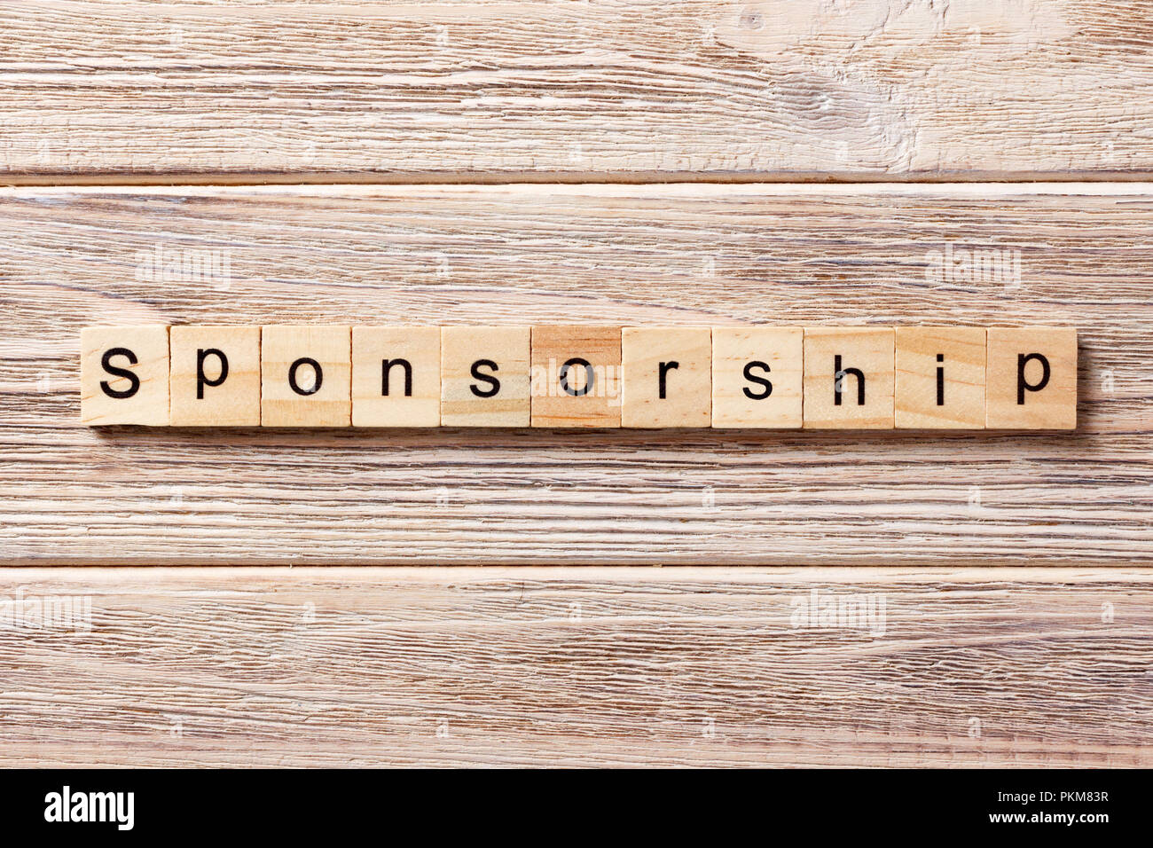 Sponsorship word written on wood block. Sponsorship text on table ...