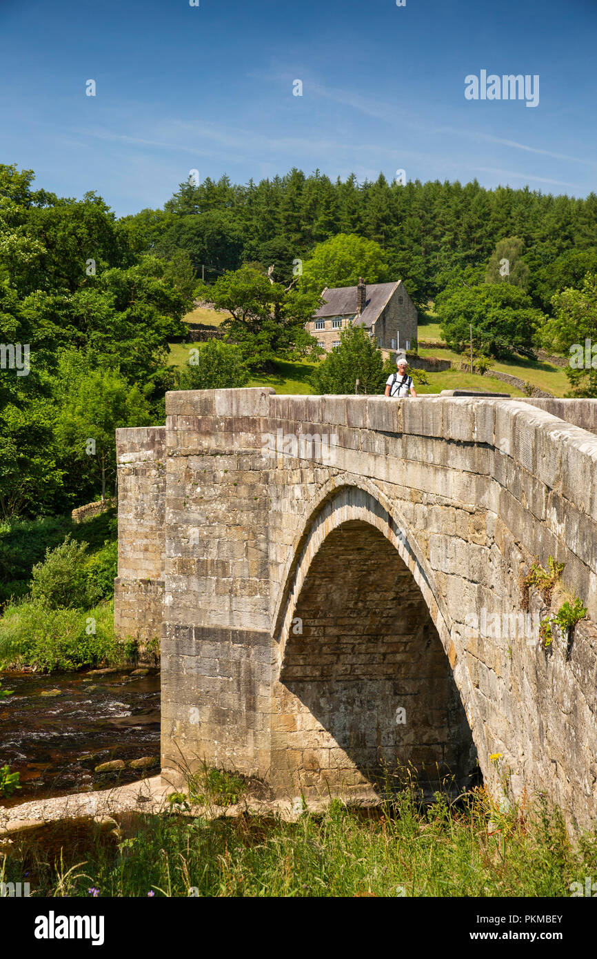 UK, Yorkshire, Wharfedale, walker crossing Barden Bridge, River Wharfe ...