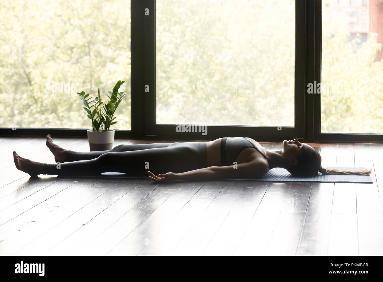 Young sporty attractive woman in Dead Body pose Stock Photo - Alamy
