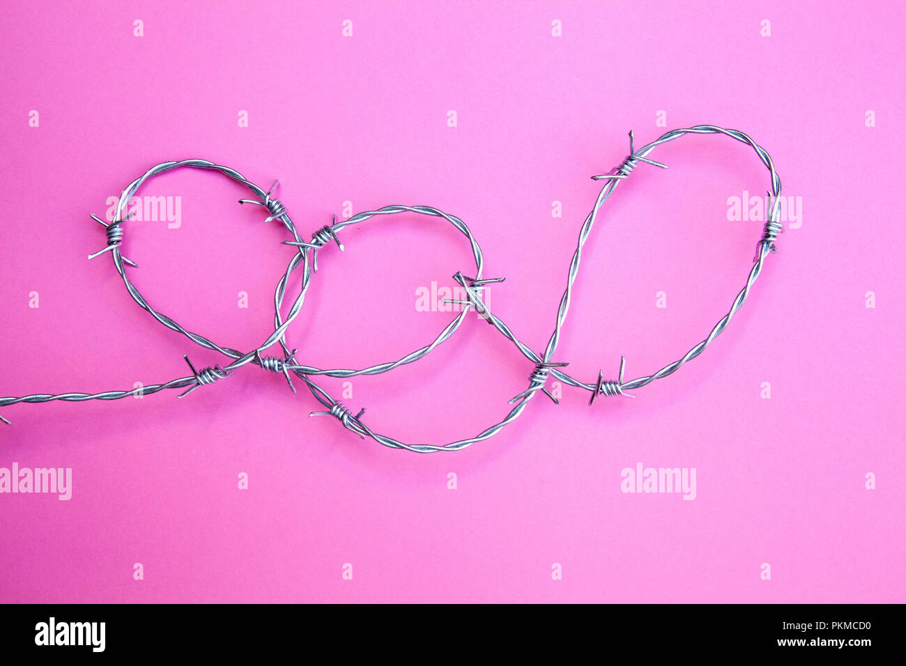 Barb Wire Loops on Pink Ground Stock Photo - Alamy