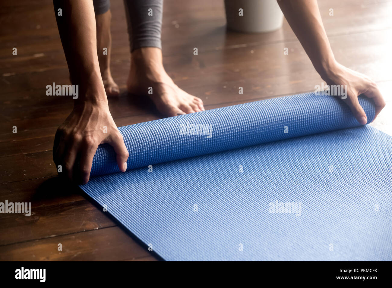 Time for practice, female hands unrolling blue yoga mat Stock Photo - Alamy