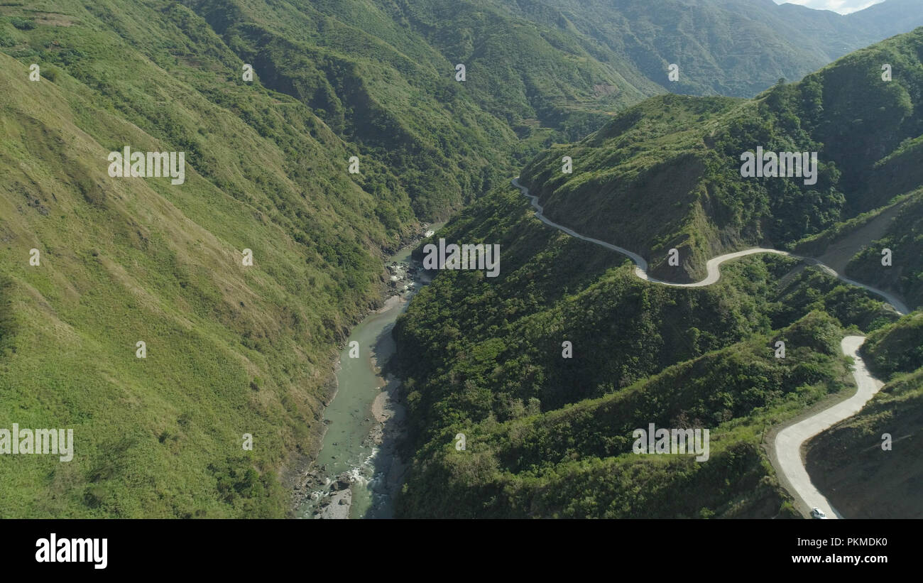 Aerial view of mountain river in the cordillera, road on the slopes ...