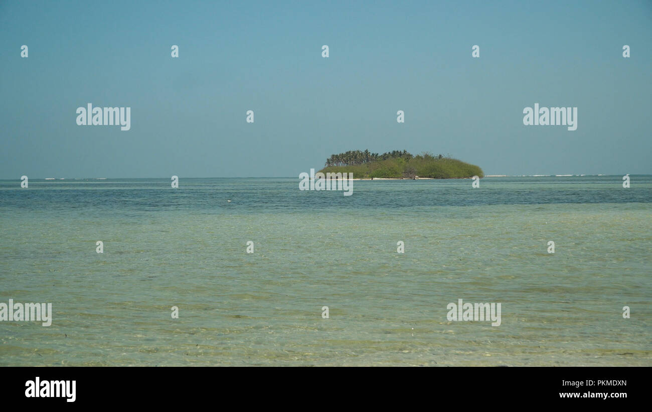 Tropical island with white sandy beach, palm trees in blue lagoon ...