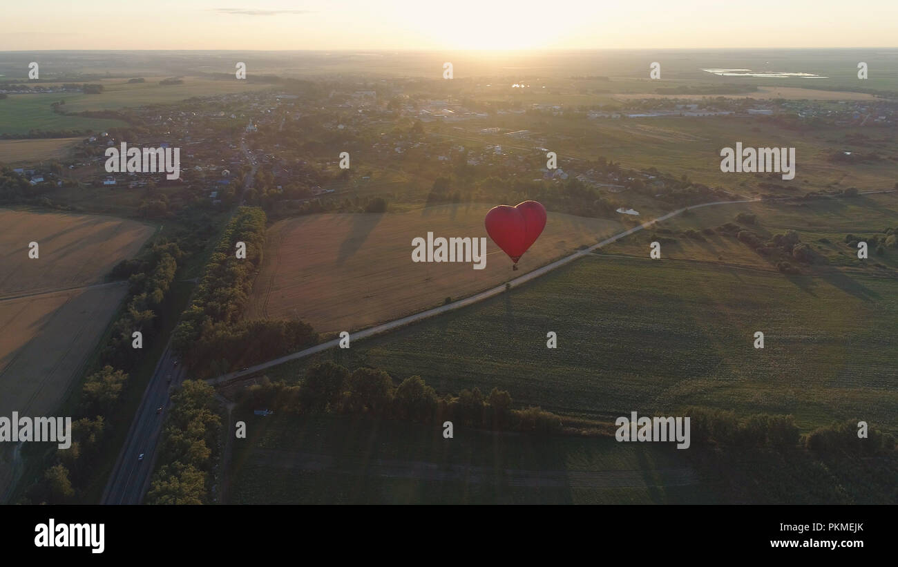 Aerial view Hot air balloon shape heart in sky over field in ...