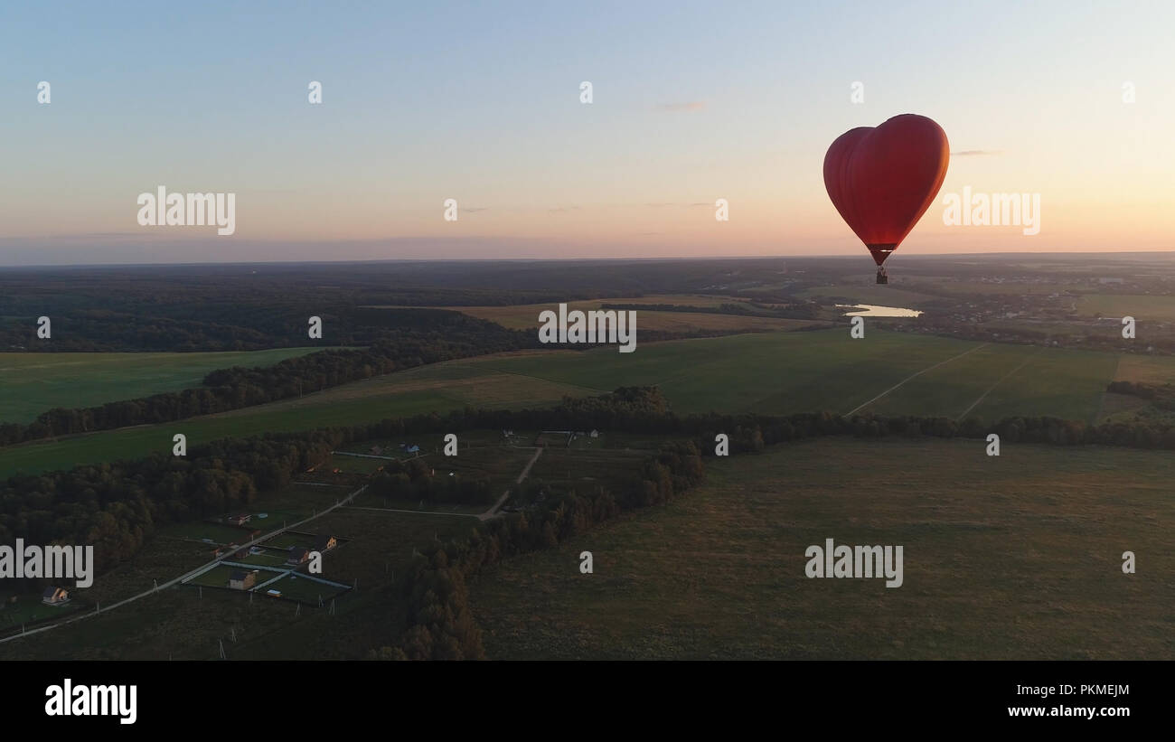 Aerial view Hot air balloon shape heart in sky over field in ...