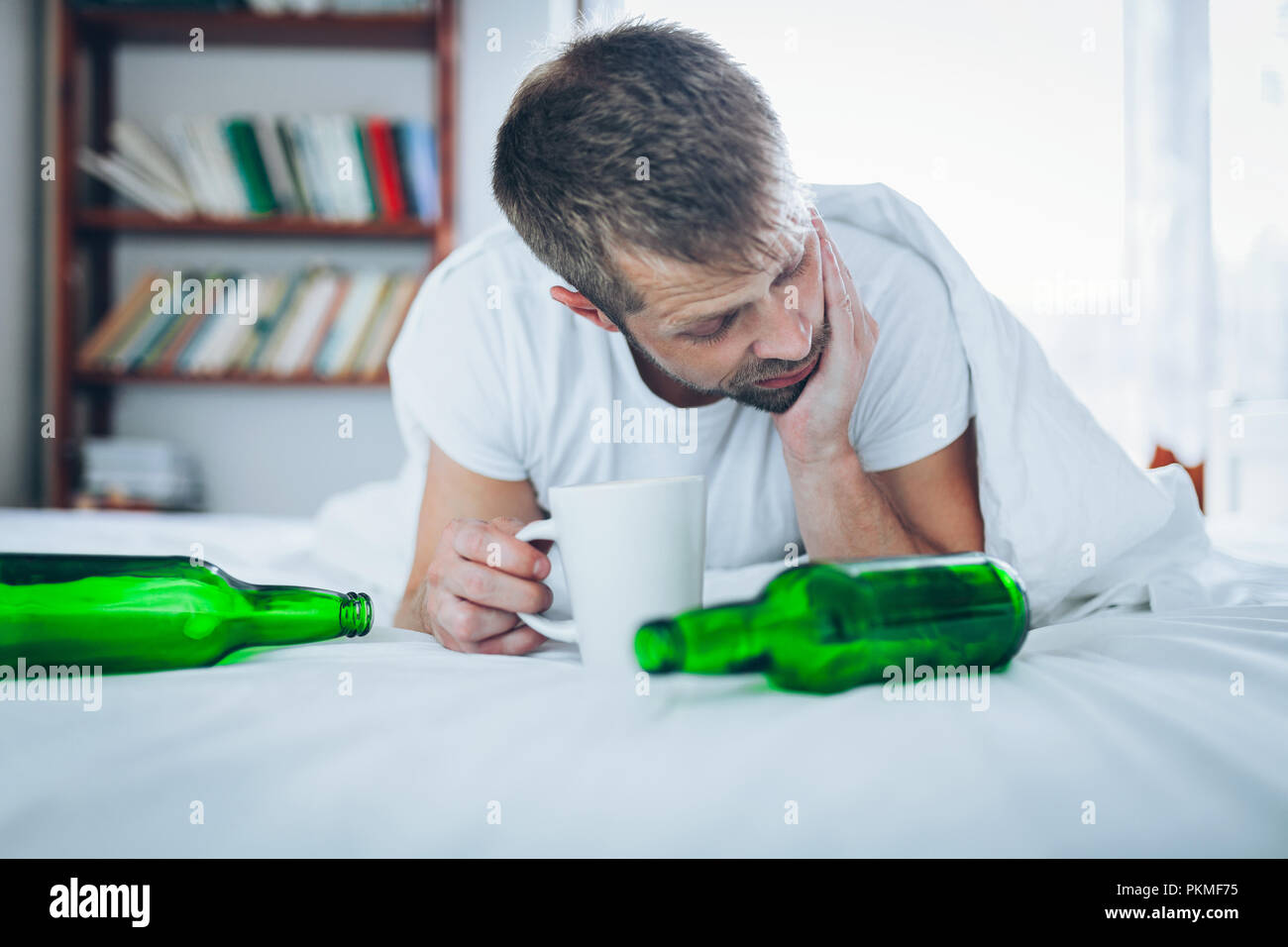 Young handsome man in bed the morning after night out drinking Stock ...