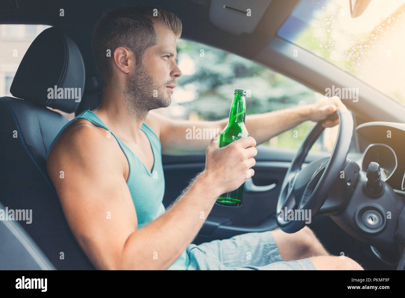 Drunk driver drinking behind the steering wheel of a car Stock Photo ...
