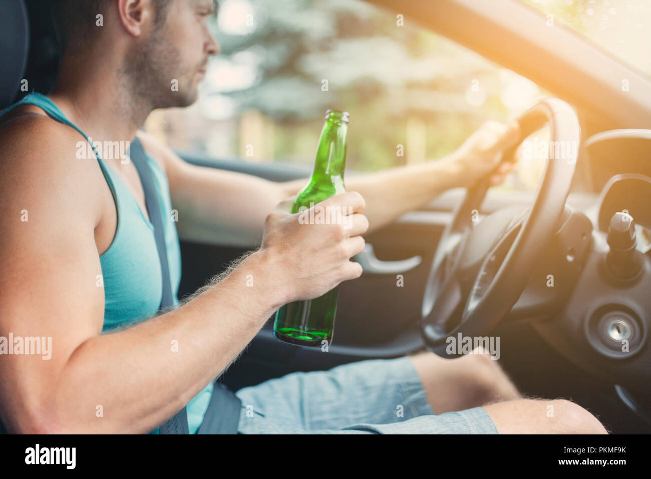 Drunk driver drinking behind the steering wheel of a car Stock Photo ...