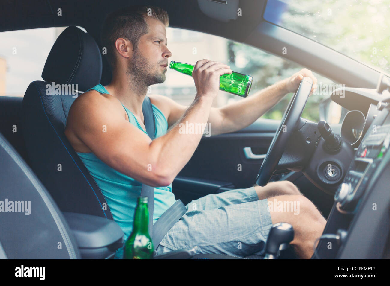 Drunk driver drinking behind the steering wheel of a car Stock Photo ...