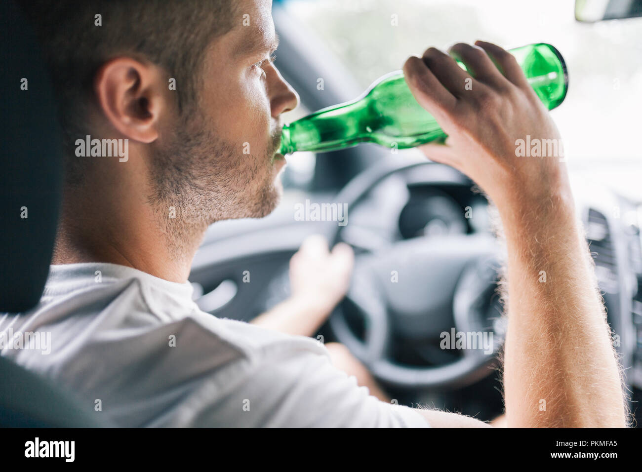 Drunk driver drinking behind the steering wheel of a car Stock Photo ...