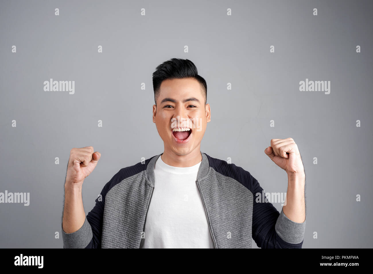 Happy handsome man cheering arms hi-res stock photography and images ...