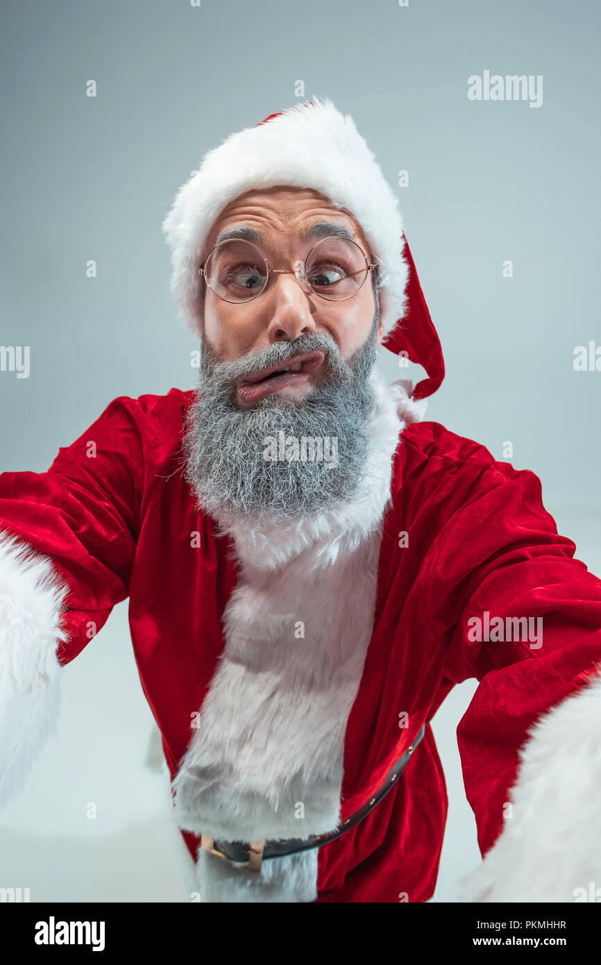 Funny surprised guy with christmas hat posing at studio. New Year ...