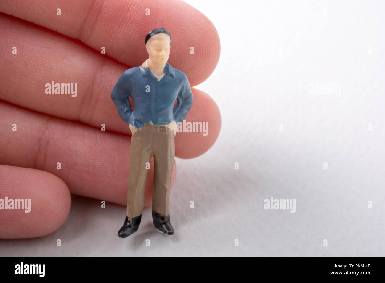 Tiny figurine of man miniature model in hand Stock Photo - Alamy
