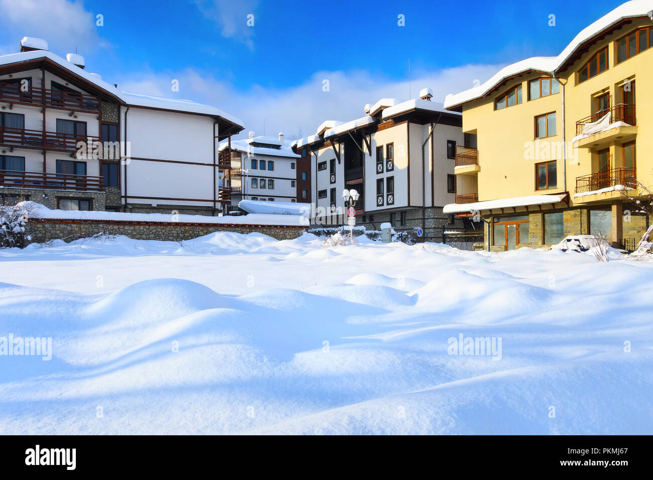 Street view, traditional houses and high snow in bulgarian ski resort ...