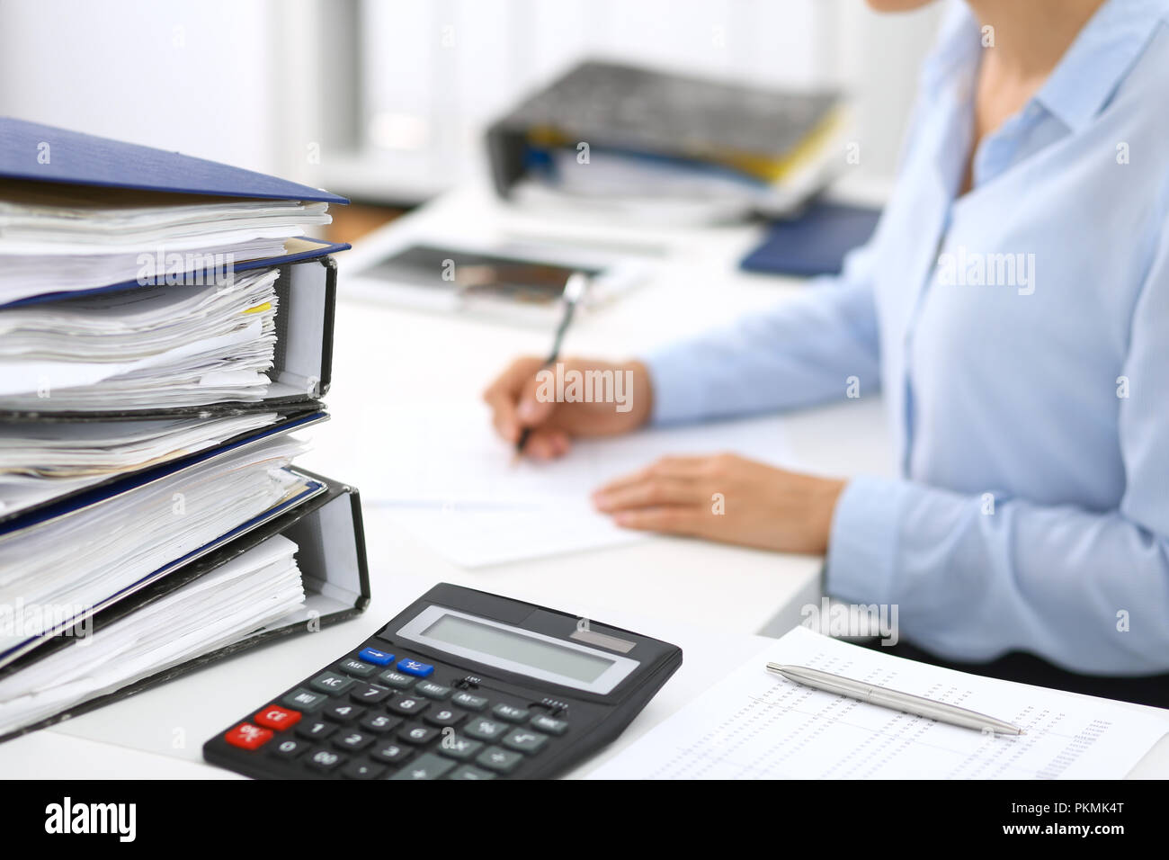 Calculator and binders with papers are waiting to be processed by ...