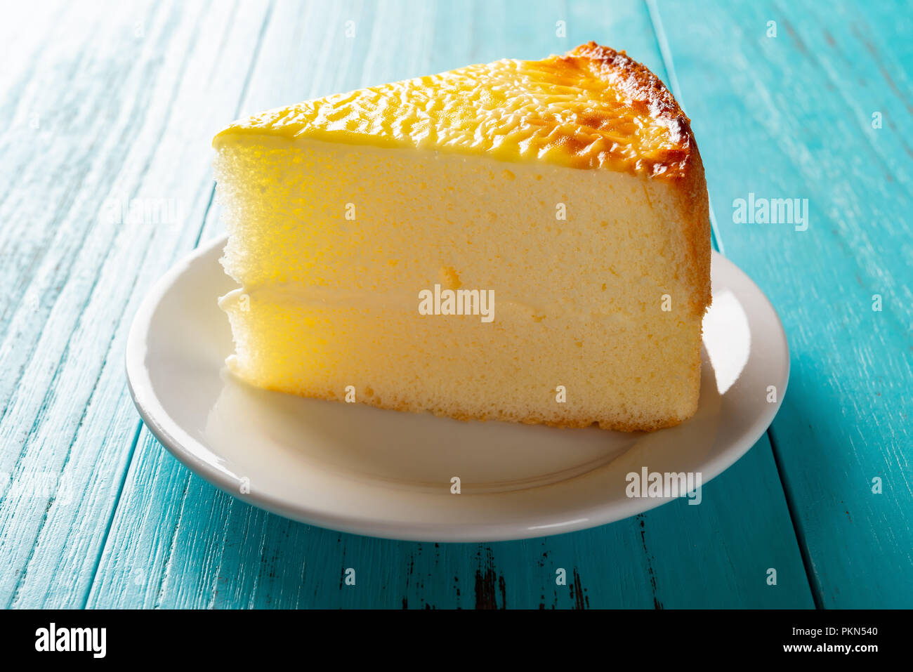 side view studio shoot of home made cheese cake on a blue table Stock ...