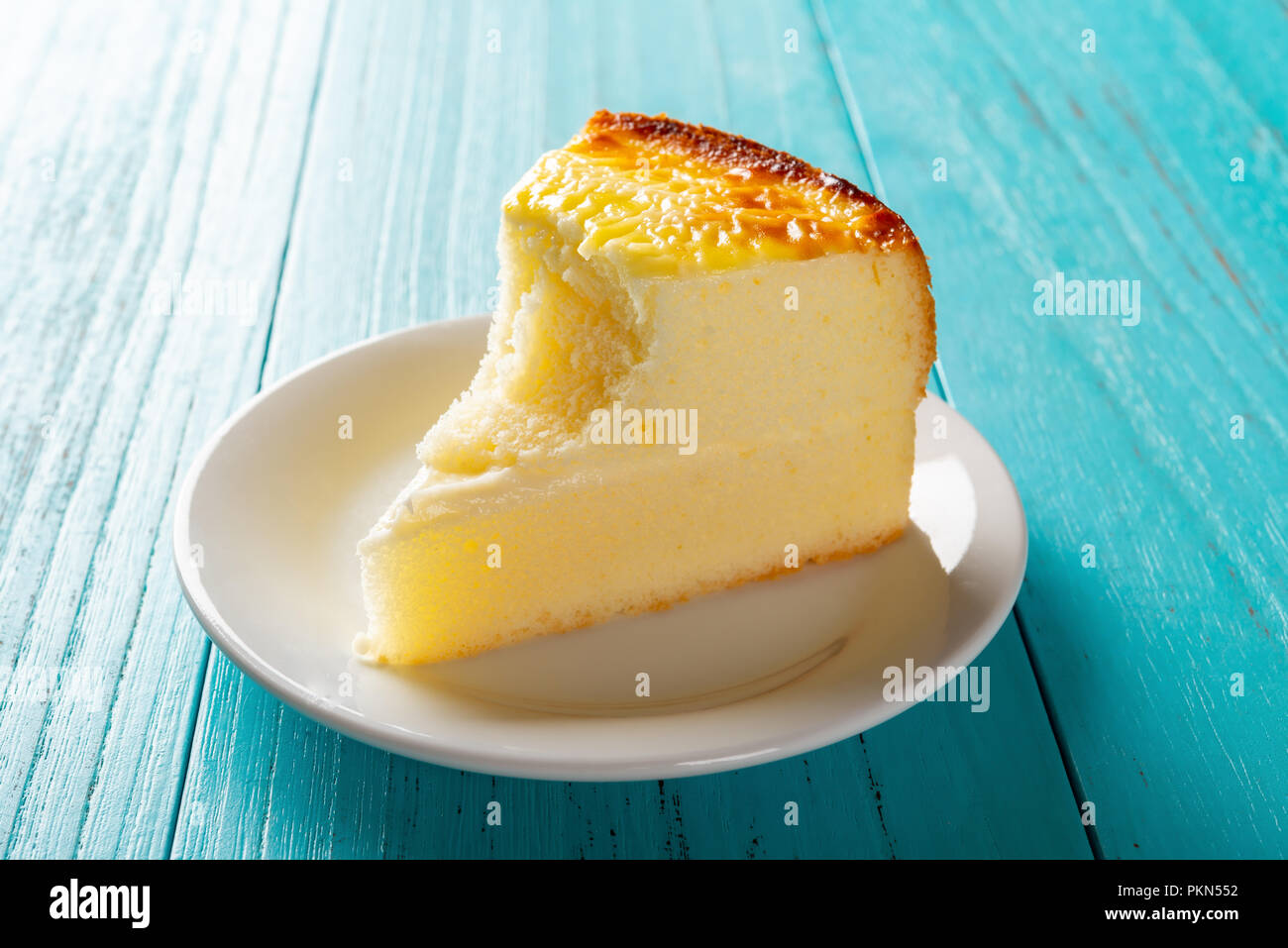 side view studio shoot of home made cheese cake on a blue table with a ...