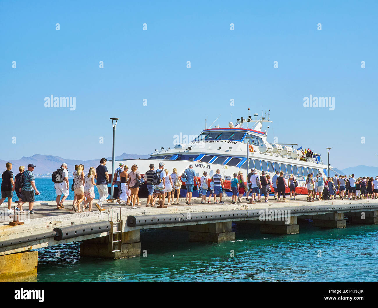 A herd of tourists boarding in a ferry at the harbour of Kos, a Greek ...