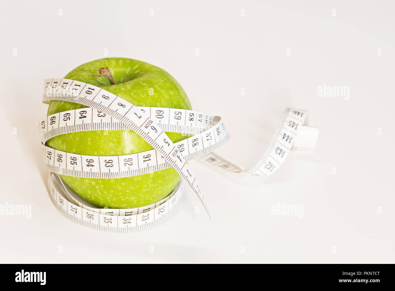 Measuring tape wrapped around a green apple Stock Photo - Alamy