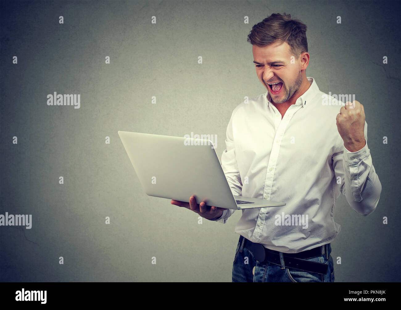 Super excited young man with laptop computer celebrating success Stock ...