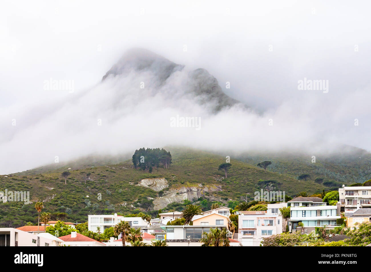 Cloud and mist covered Table Mountain behind houses in Camps Bay, South ...