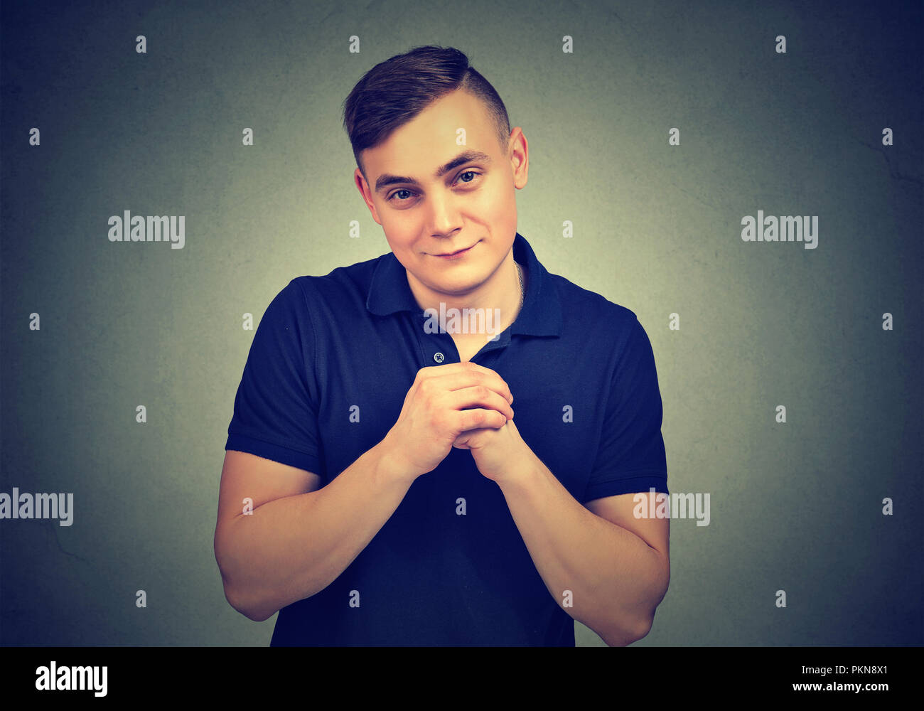 Young casual man feeling guilty looking at camera in apology on gray ...