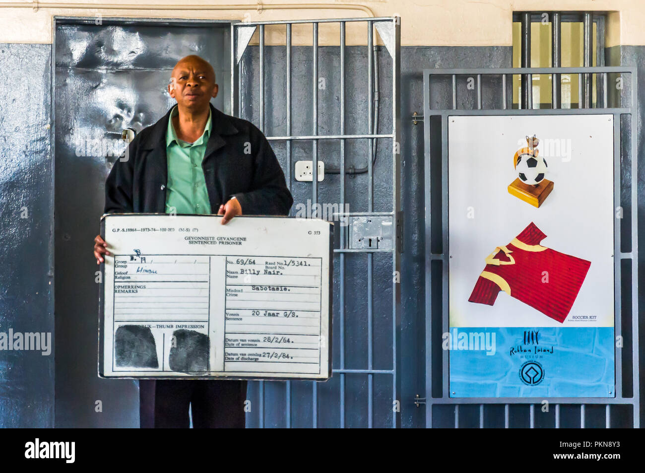A tour guide shows the paperwork of a prisoner of Robben Island ...