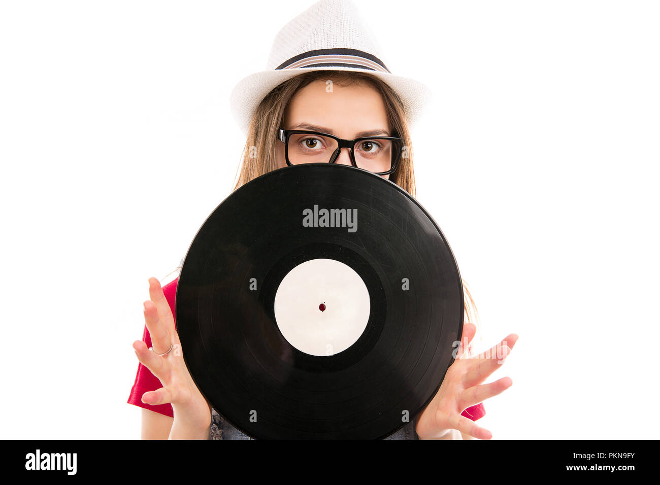 Stylish woman in hat and glasses hiding face behind retro vinyl disk ...