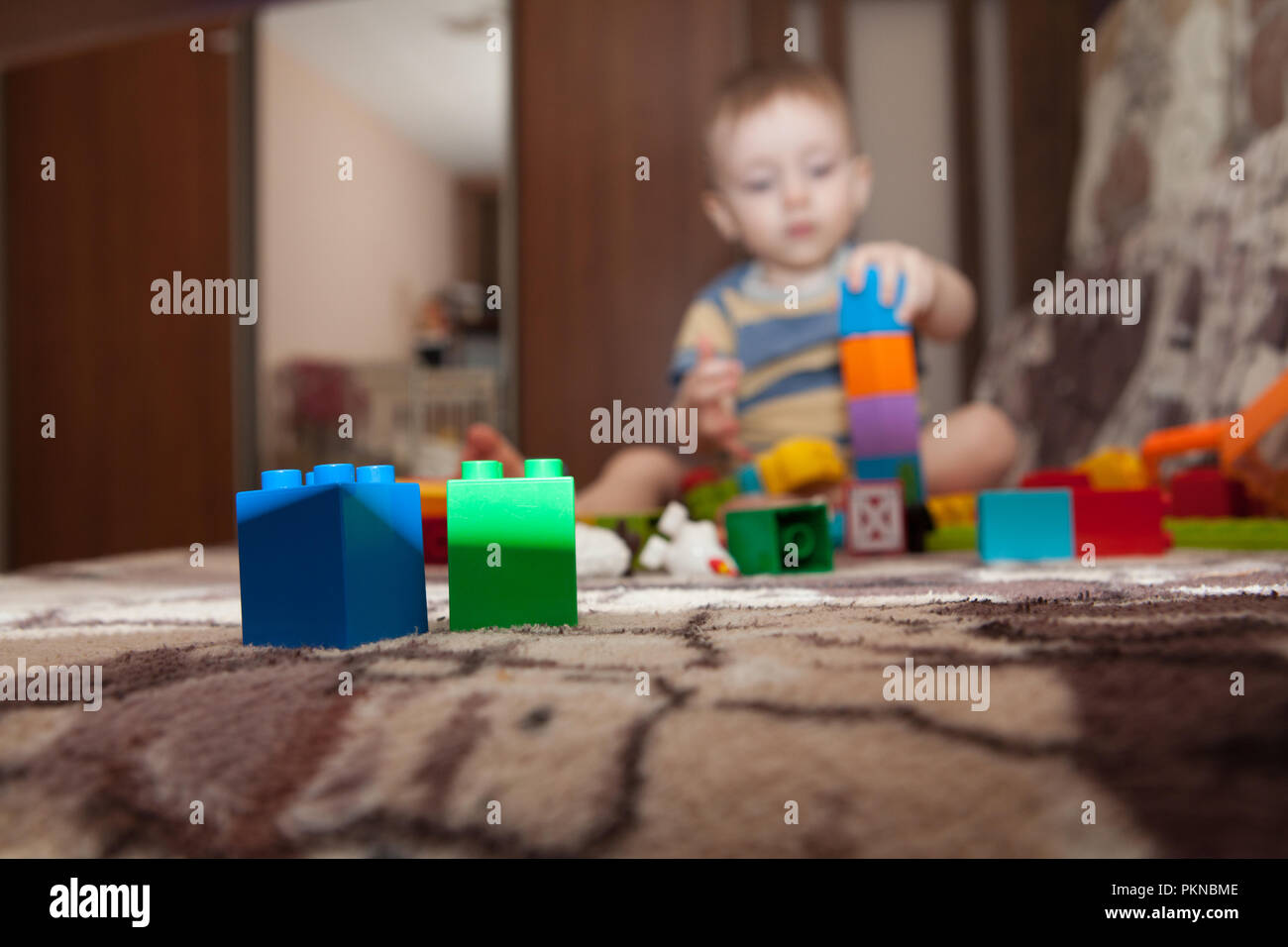 Sweet little boy building tower from cubes at home Stock Photo - Alamy