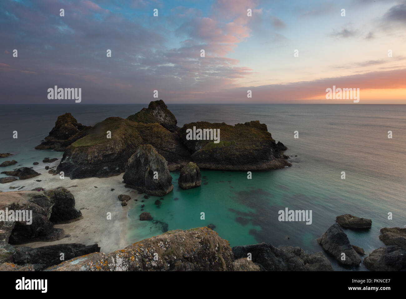 A landscape image of the sandy beach and rugged cliffs around Kynance ...