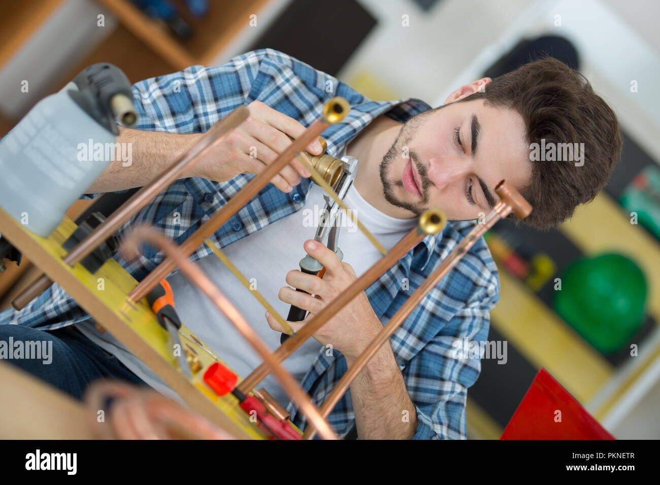 Young man working on copper pipes Stock Photo - Alamy