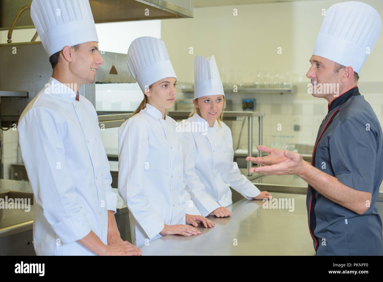 Chef addressing trainee cooks Stock Photo - Alamy