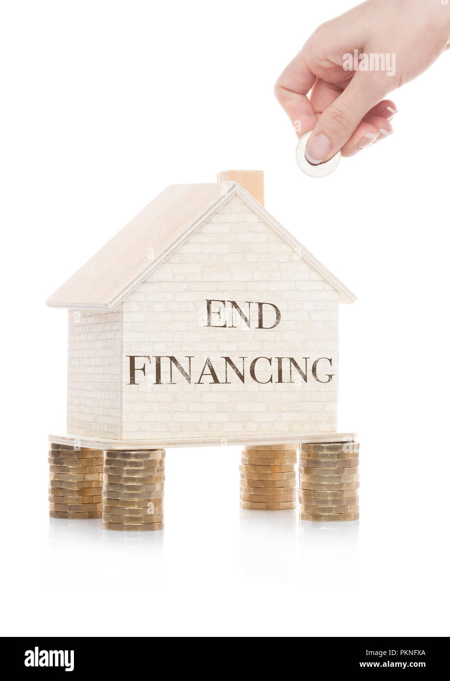 Wooden house model standing on coins and hand holding the coin with ...