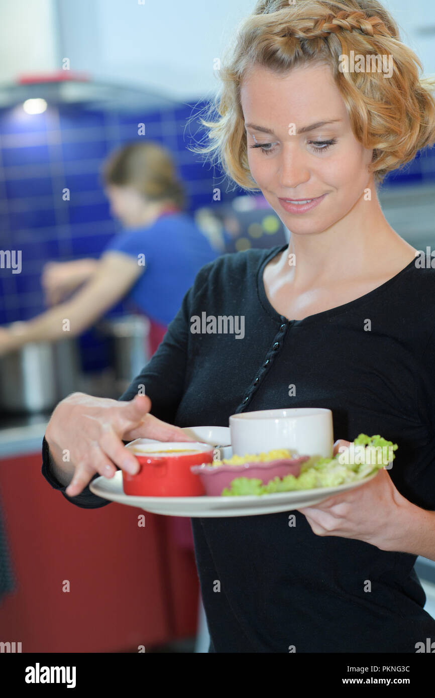 smiling female waitress taking plate at restaurant kitchen Stock Photo ...