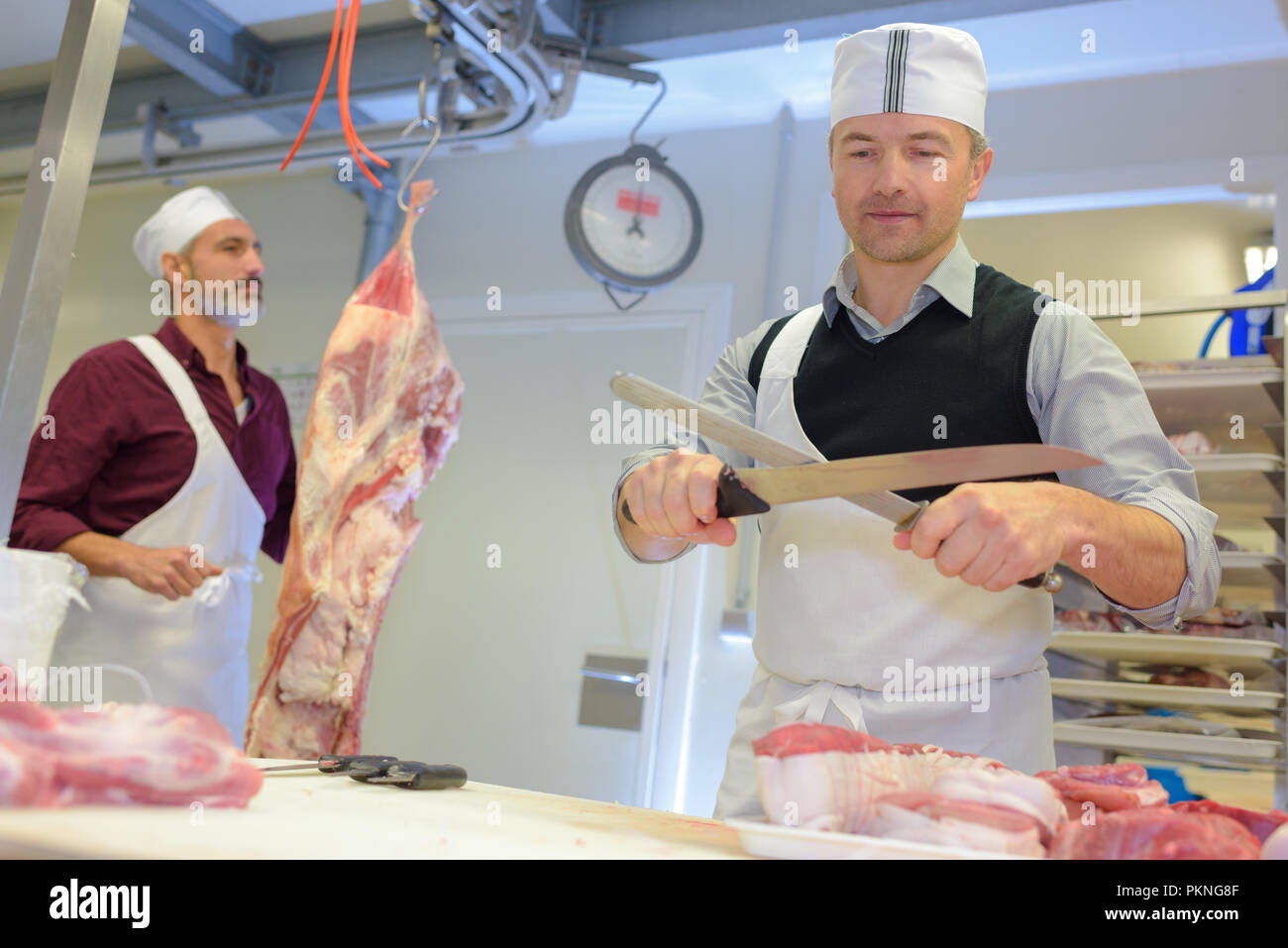Butcher sharpening knife with a steel Stock Photo - Alamy