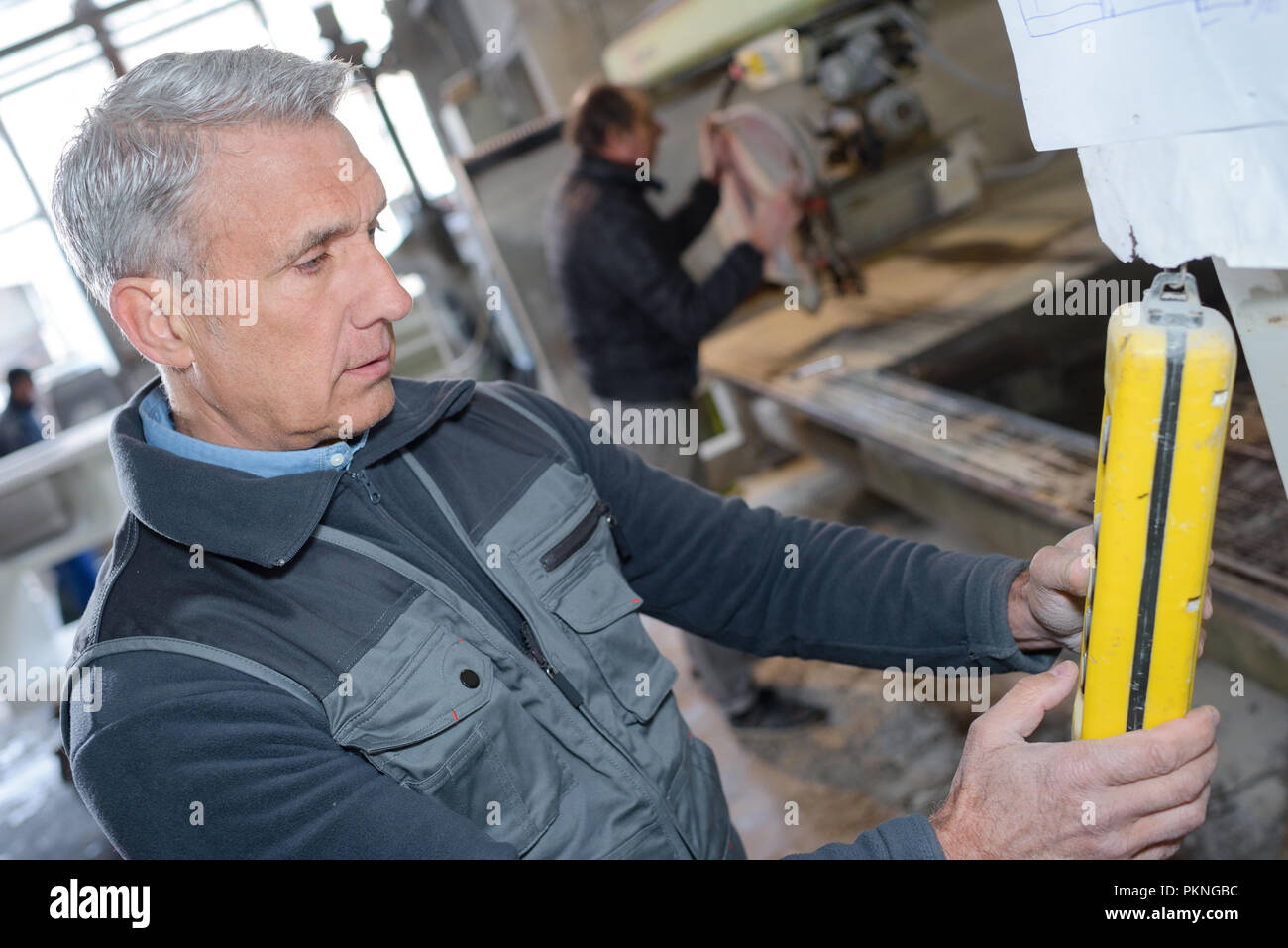 factory machine operator adjusting the setting of a machine Stock Photo ...