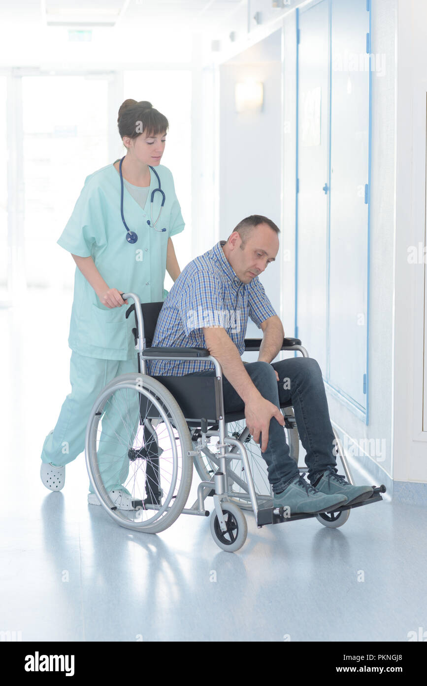 nurse pushing a patient on wheelchair Stock Photo - Alamy