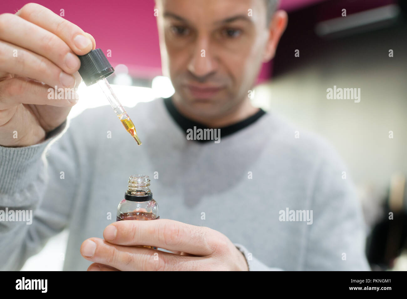 man holding drop bottles Stock Photo - Alamy
