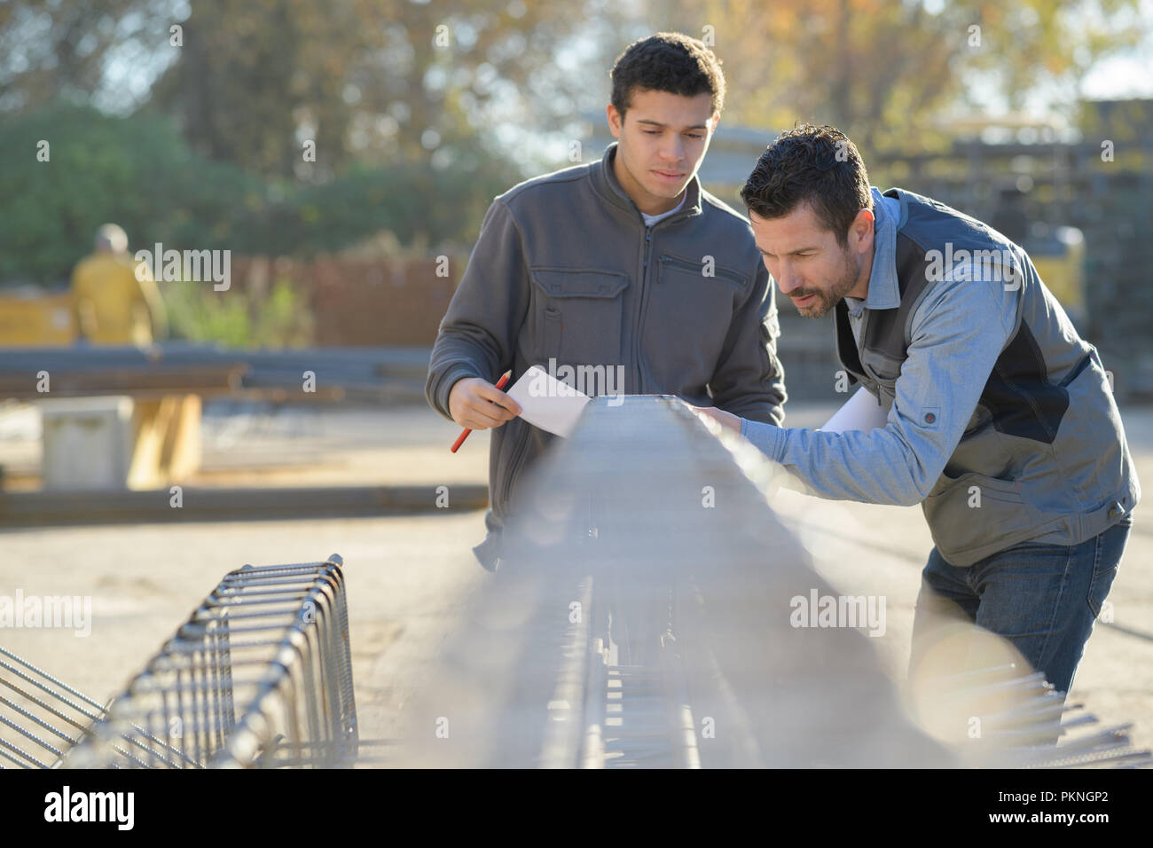 Workmen counting metal bars Stock Photo - Alamy
