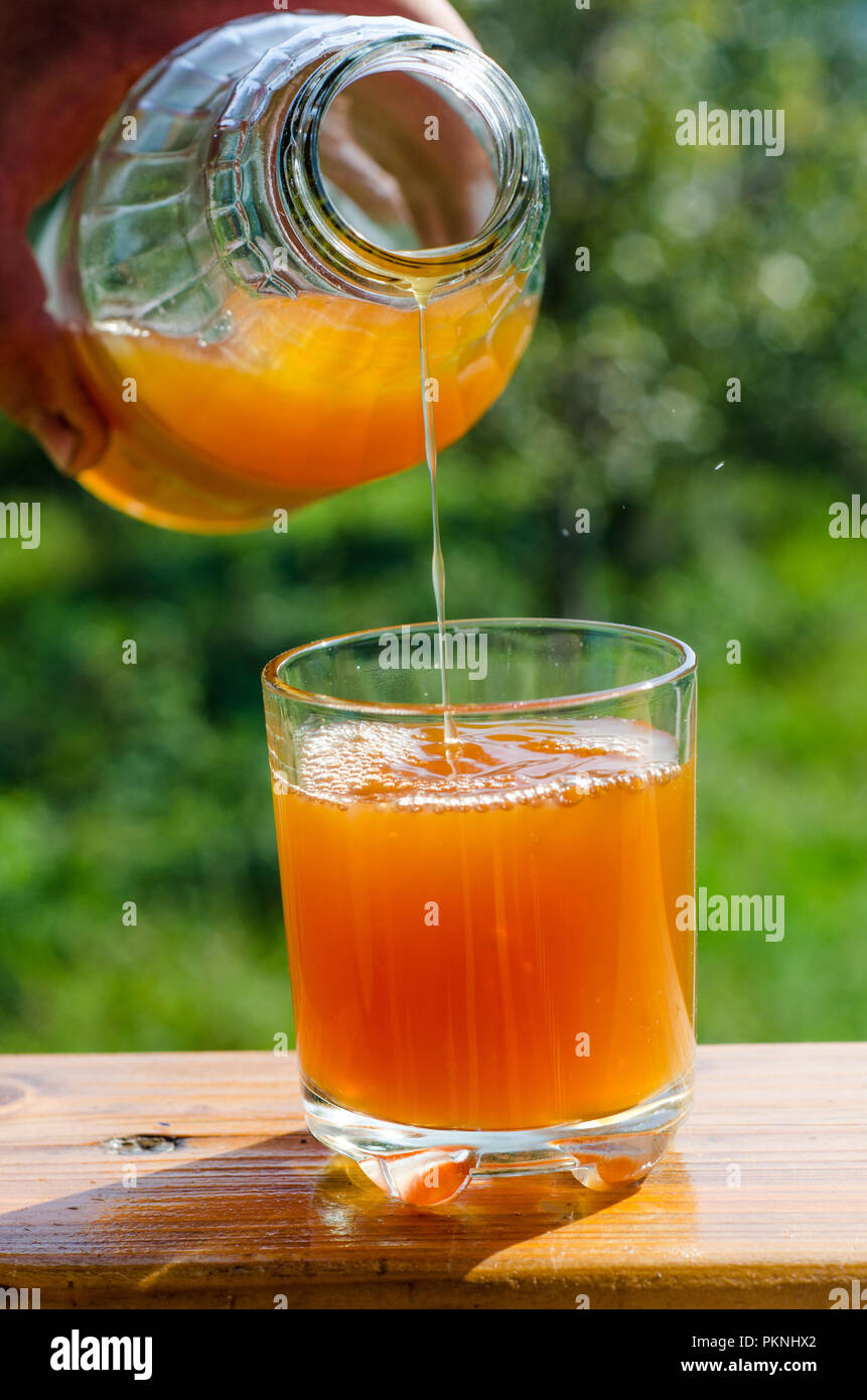 pouring fresh raw unfiltered apple juice into a glass Stock Photo - Alamy