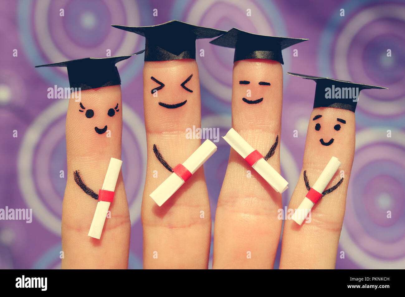 Finger art of students. Graduates holding their diploma after ...