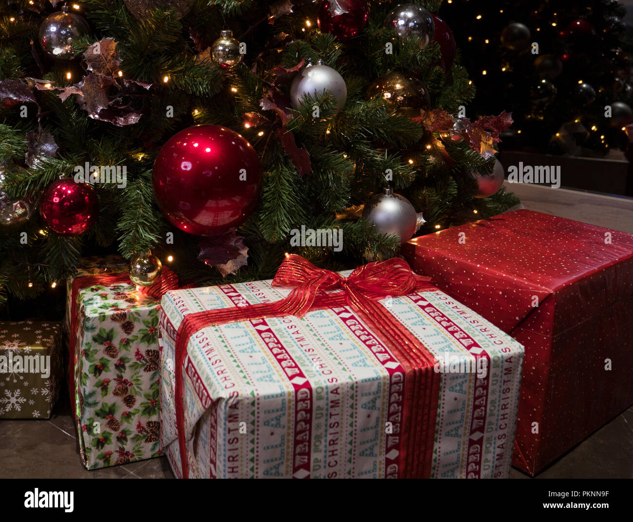 Christmas presents by Christmas tree Stock Photo - Alamy