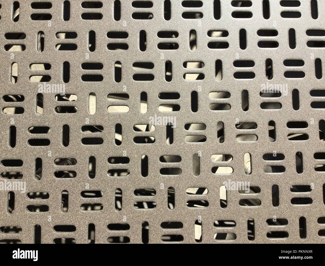 Gray metal surface with patterns of holes in sets Stock Photo - Alamy