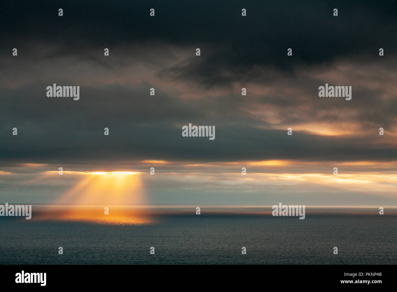 Shaft of sunlight through clouds hitting the sea Stock Photo - Alamy
