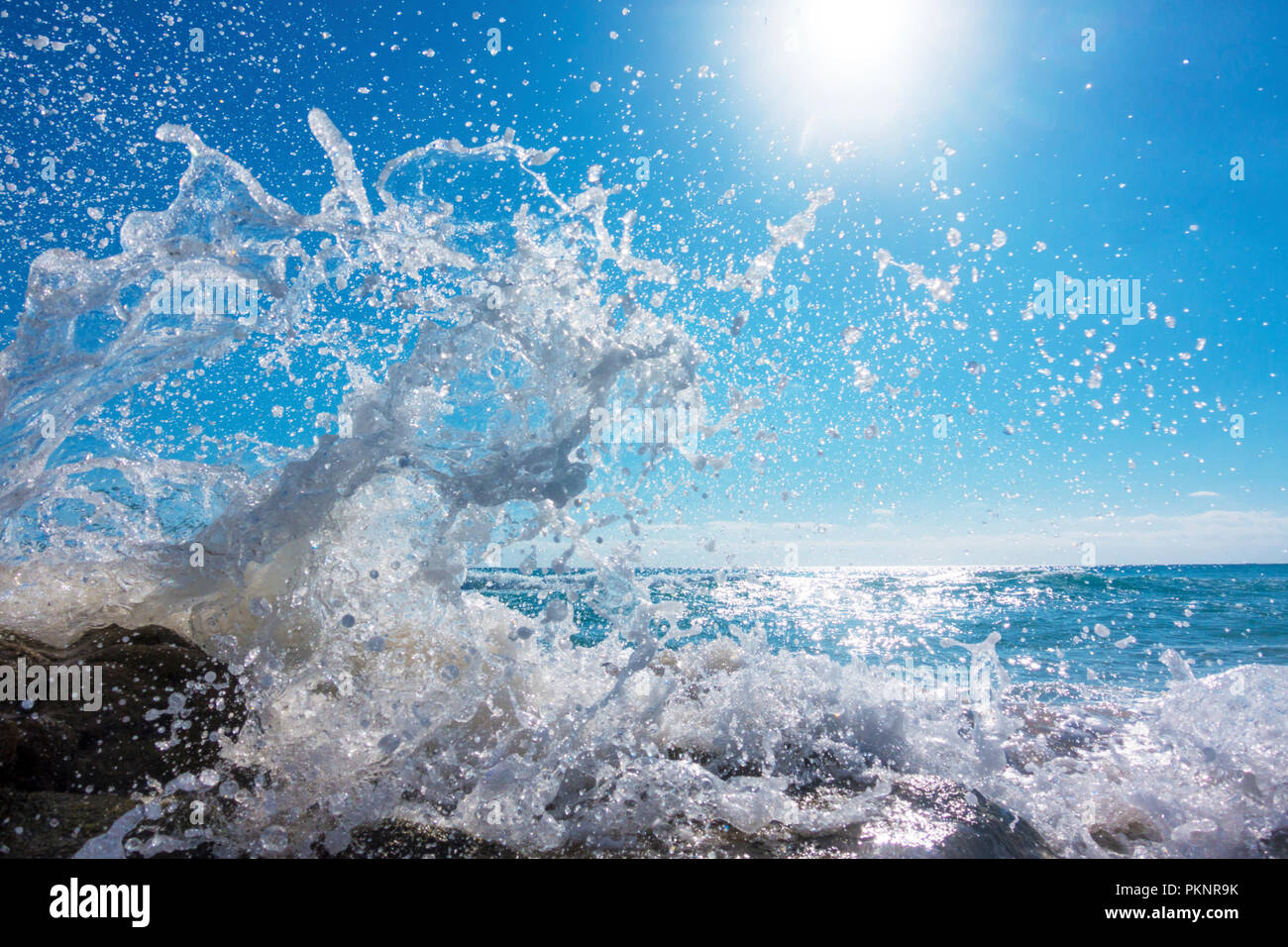 Waves breaking against rocks Stock Photo - Alamy