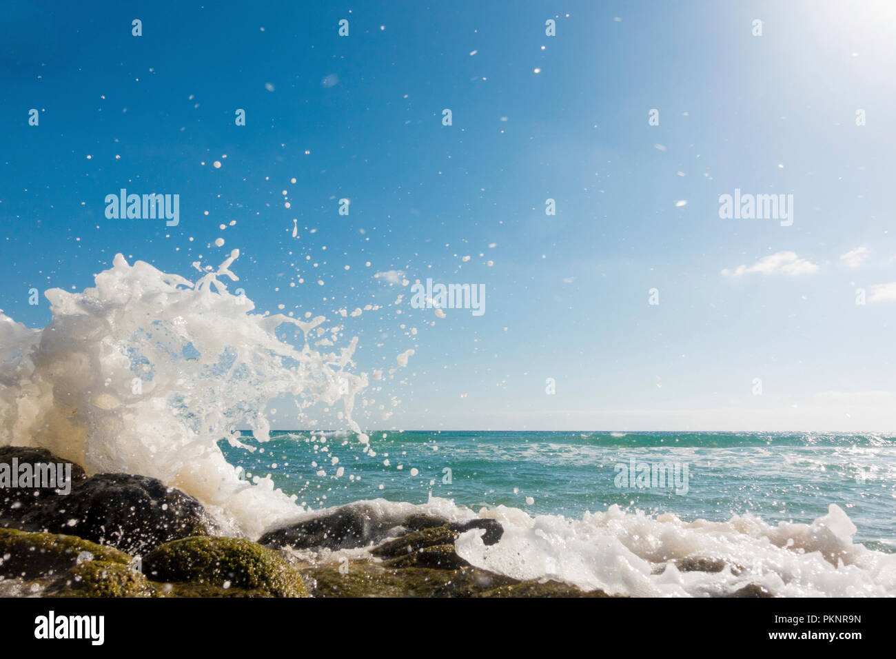 Waves breaking against rocks Stock Photo - Alamy