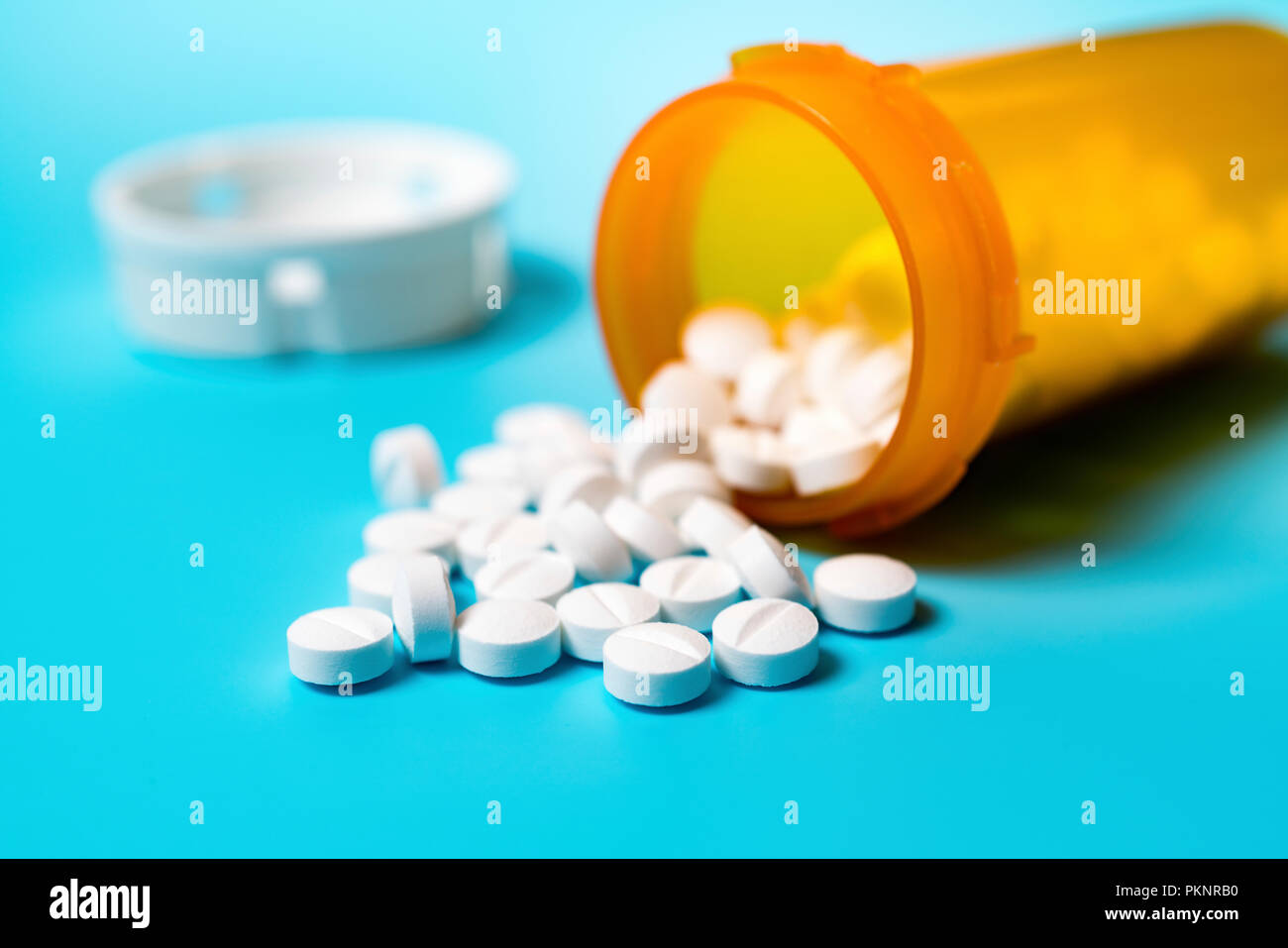 Tablets spilling from container Stock Photo - Alamy