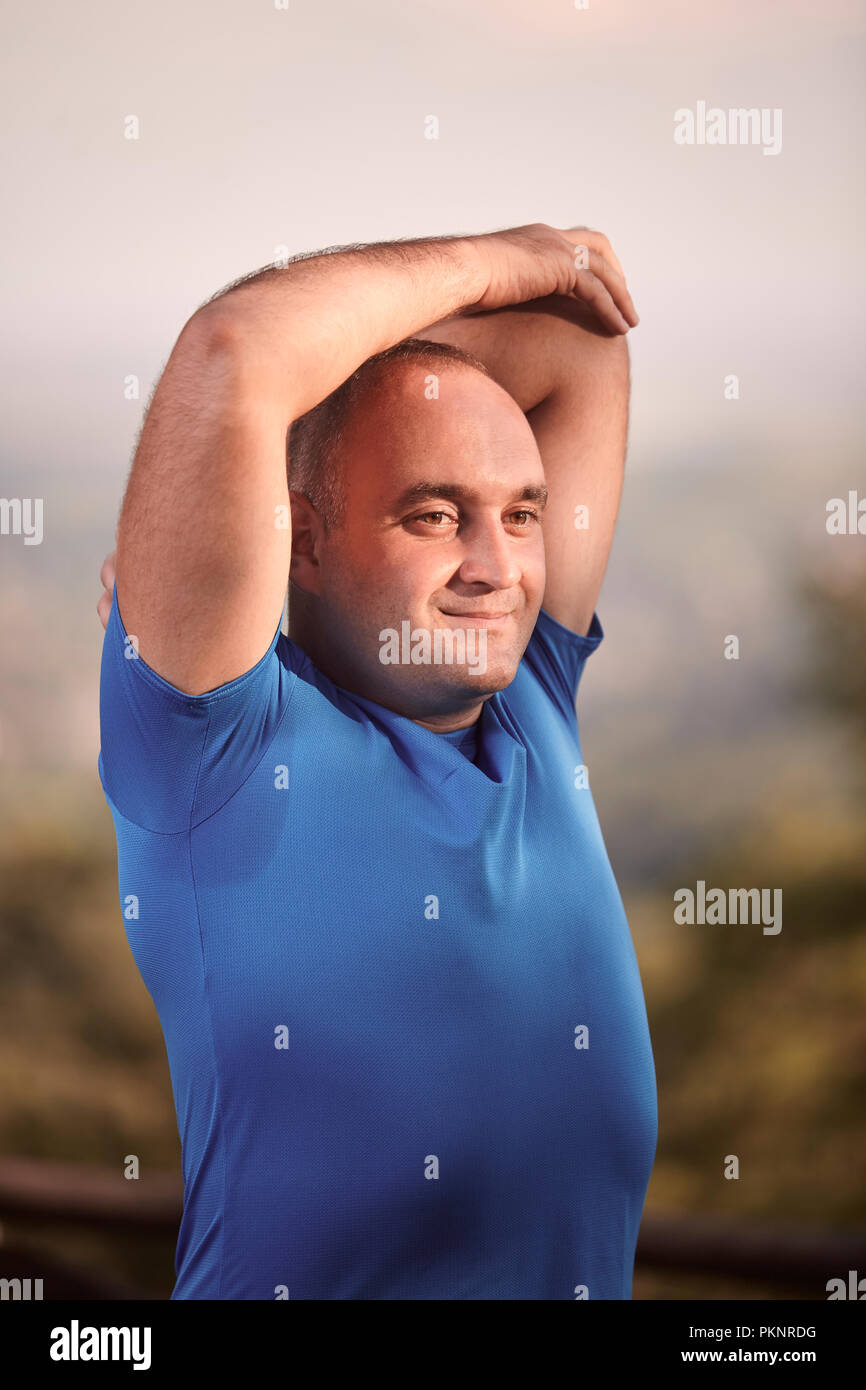 one young overweight man, smiling happy, looking sideways, upper body ...