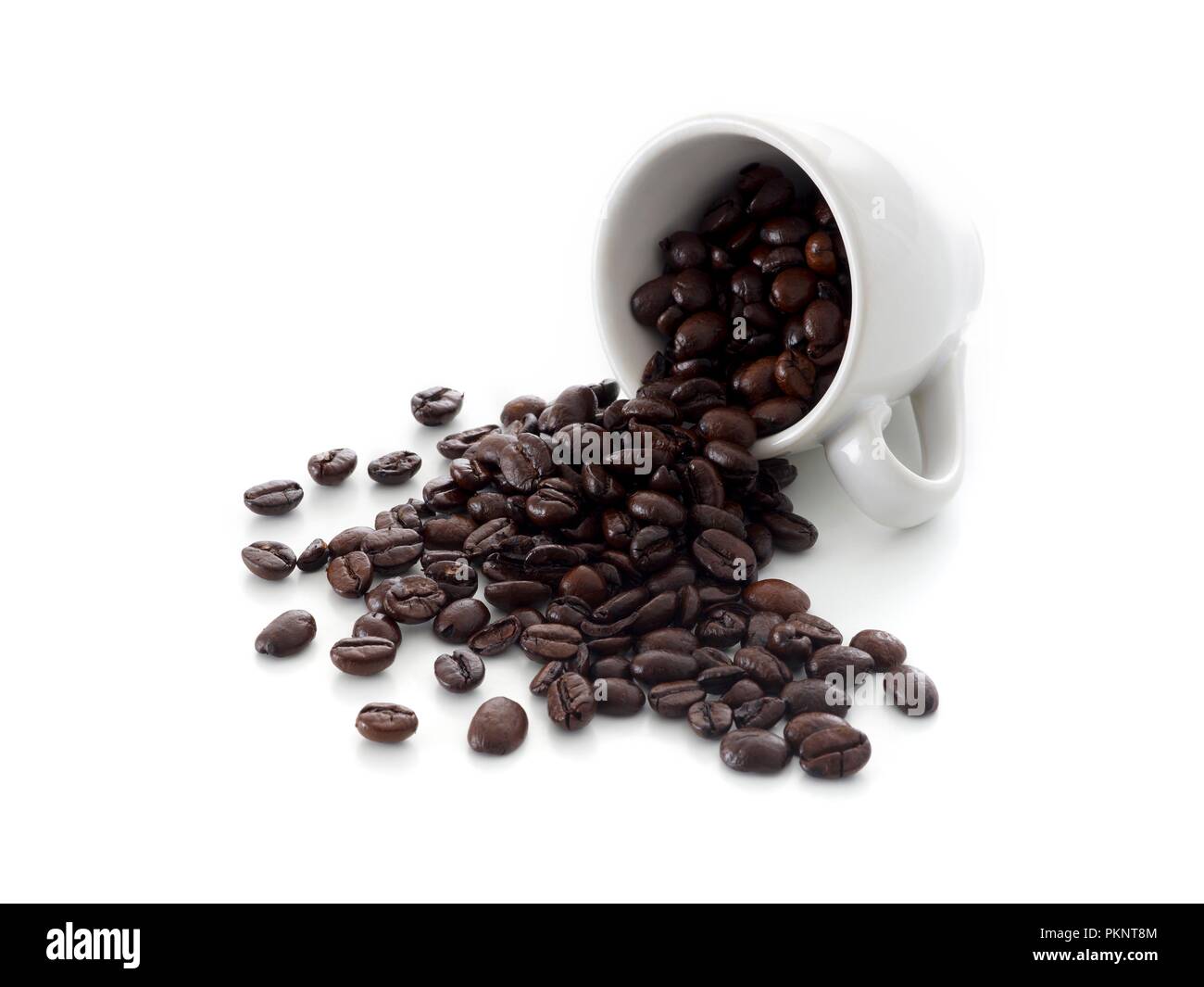 Coffee beans spilling from cup Stock Photo - Alamy